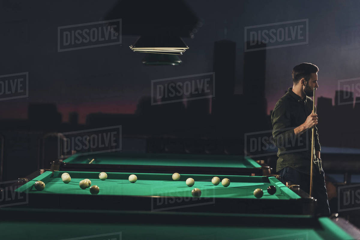 Successful handsome man standing beside pool table at bar - Royalty ...
