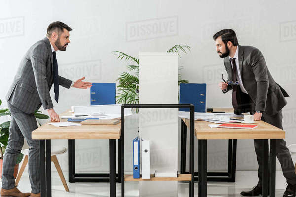 Two businessmen quarreling through partition in office - Royalty-free ...