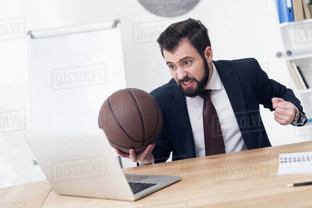 Angry businessman with basketball ball at workplace in office - Royalty ...