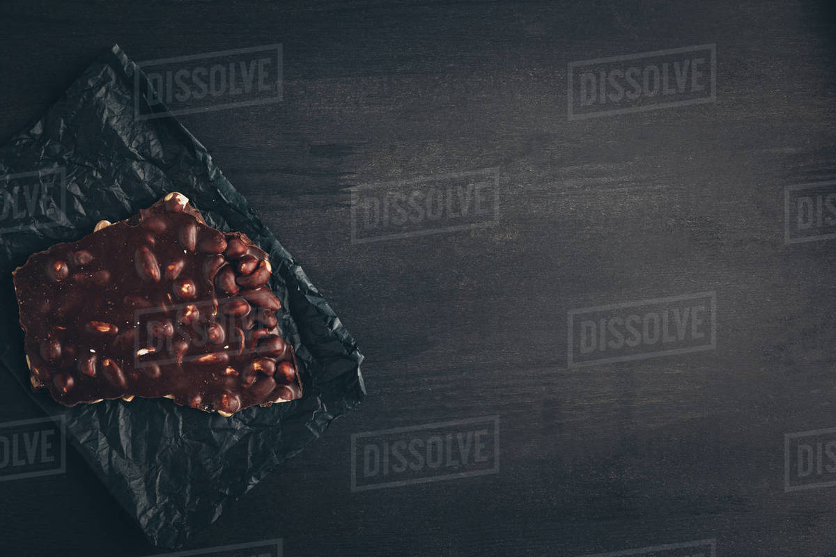Top view of chocolate with nuts on gray wrapper on wooden table - Stock ...