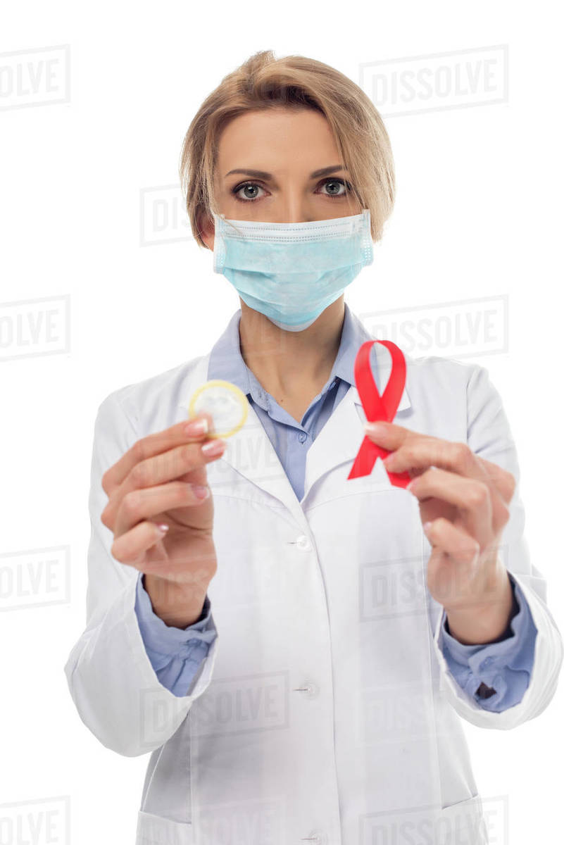 Female doctor in medical mask with aids ribbon and condom isolated on ...