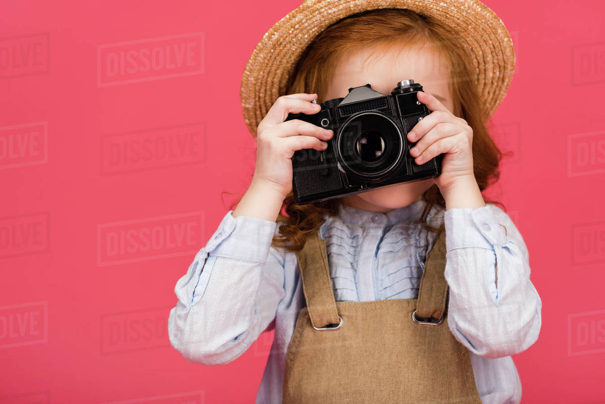 obscured view of child holding photo camera isolated on pink - Stock ...