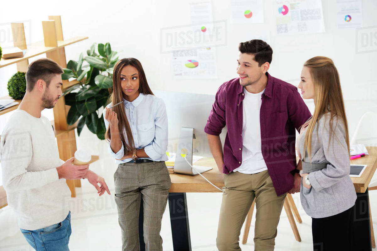 Group of young stylish multiracial business people having conversation ...