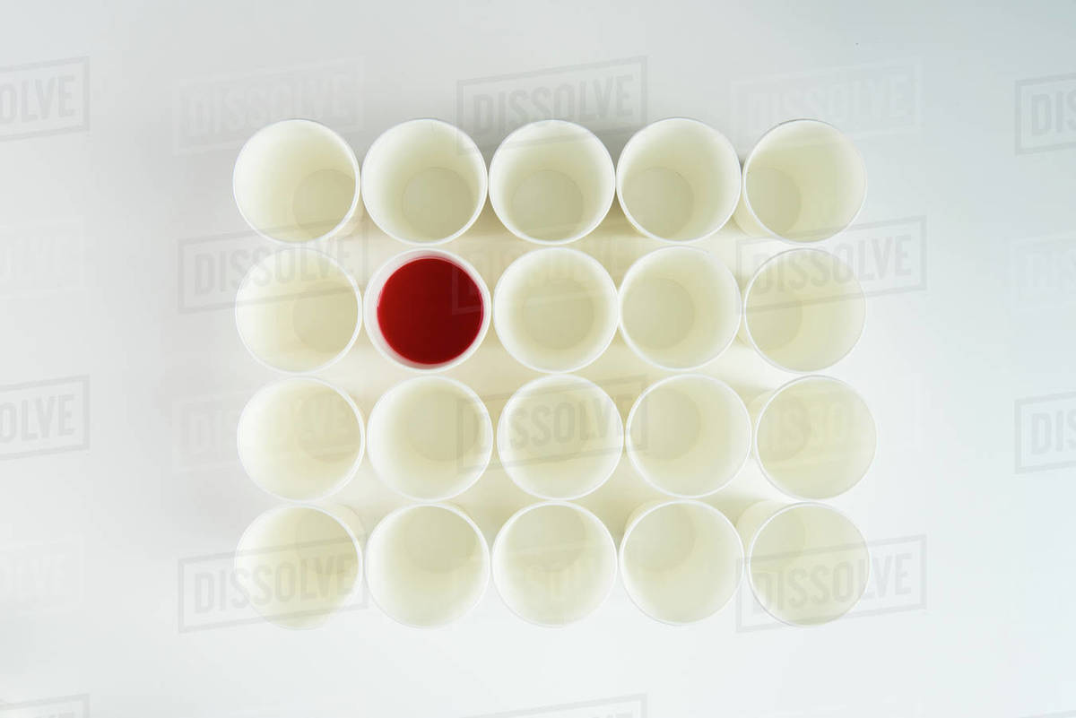 Top view of set of empty plastic cups and one with red paint - Royalty ...