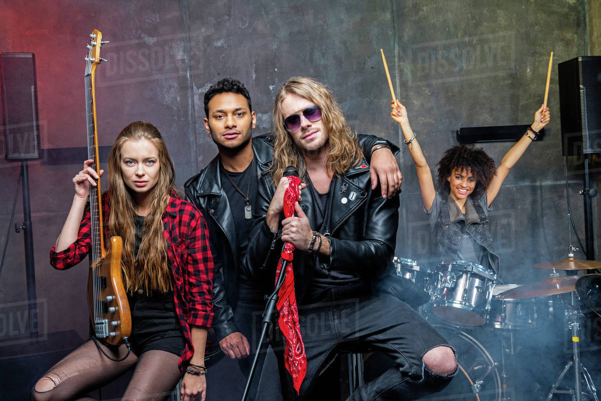 Rock band posing in studio after rehearse - Stock Photo - Dissolve