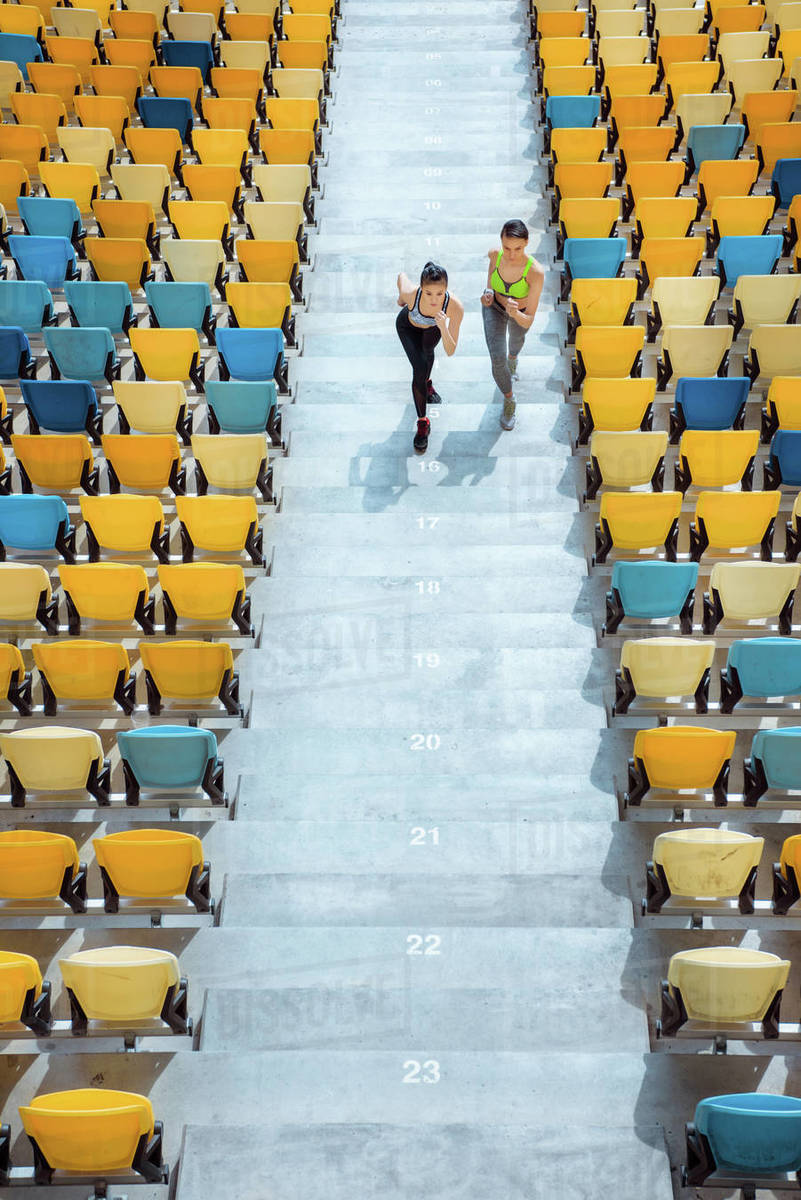 Two sportswomen running on stadium stairs, running women concept ...