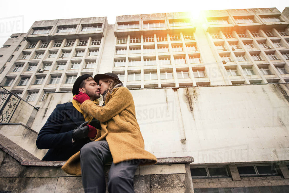 Cheerful attractive young couple hugging in front of building - Stock ...