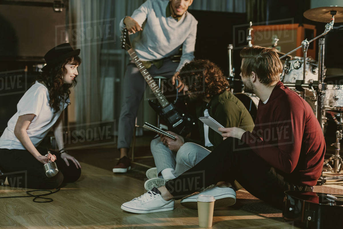 music band sitting on floor and creating text for song together ...