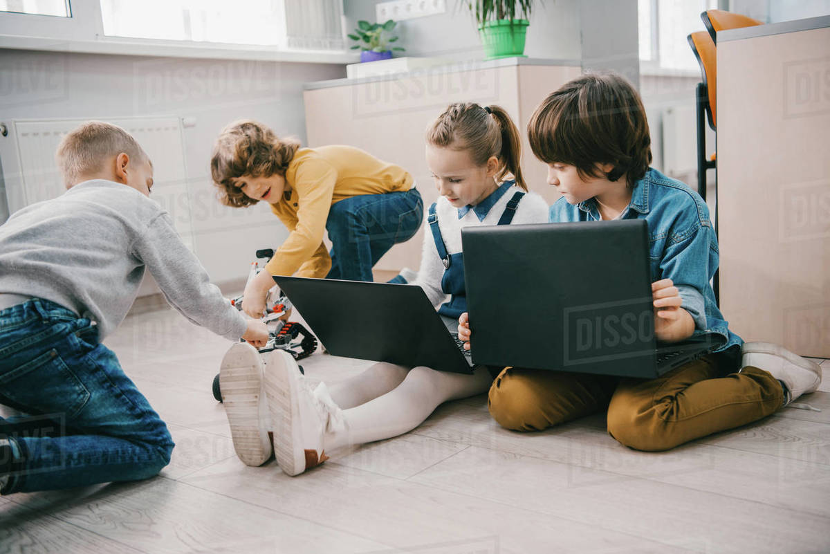 happy kids working with laptops on floor, stem education concept ...