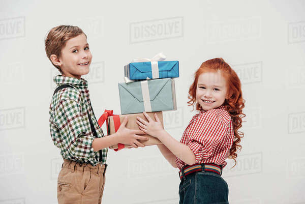 cute little children holding gift boxes and smiling at camera isolated ...