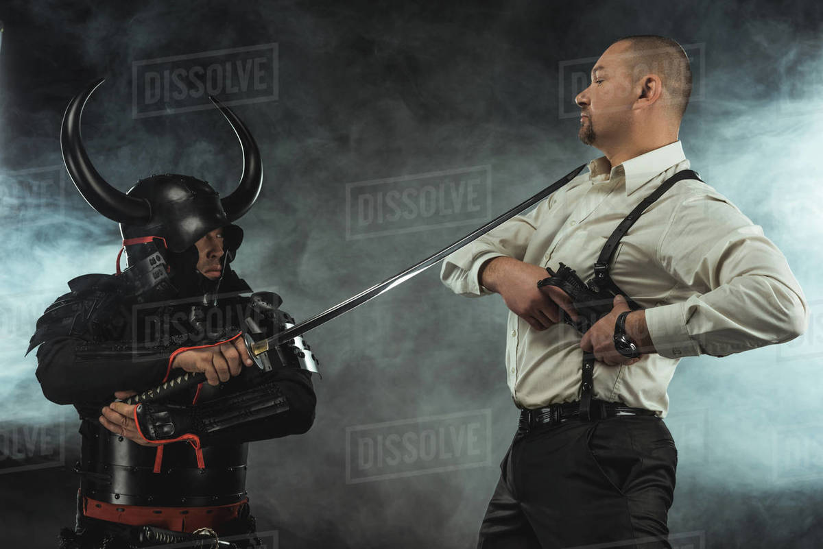 Armored samurai with katana ready to kill man while he taking out his ...