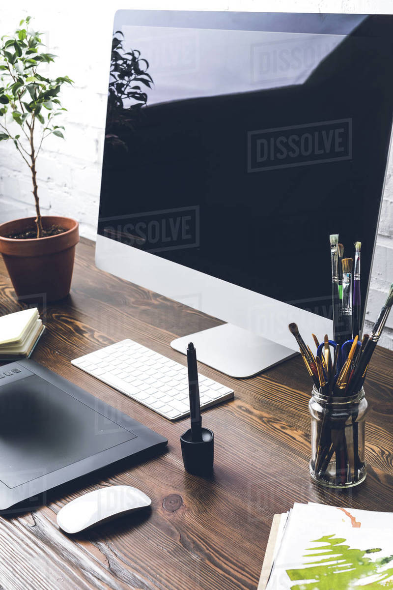 Desktop computer with blank screen, gadgets and office supplies at ...