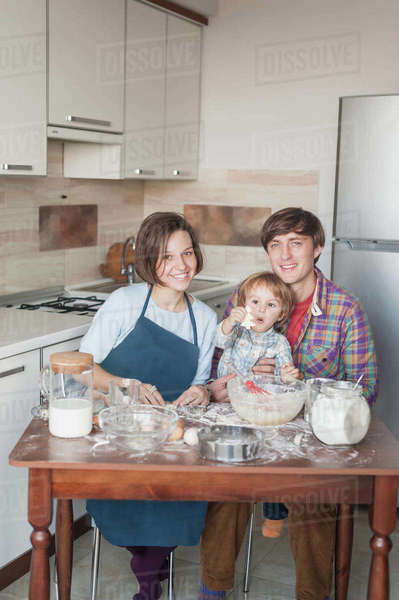 young family preparing cookies in shape of christmas tree - Royalty ...
