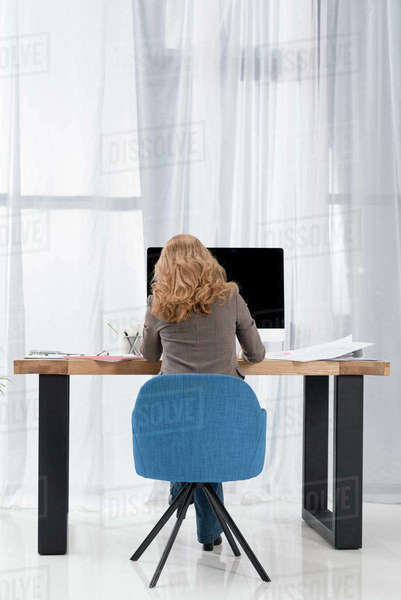 back view of businesswoman working at workplace with computer screen in ...