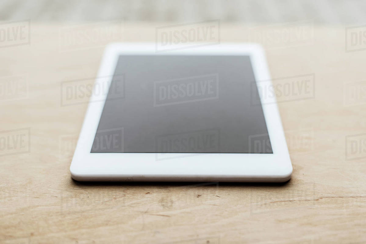 One turned off tablet on wooden table - Royalty-free Stock Photo | Dissolve