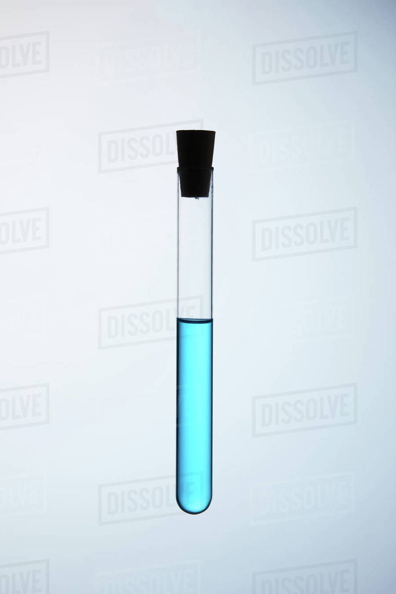 test tube filled with blue liquid floating in air on grey - Stock Photo ...