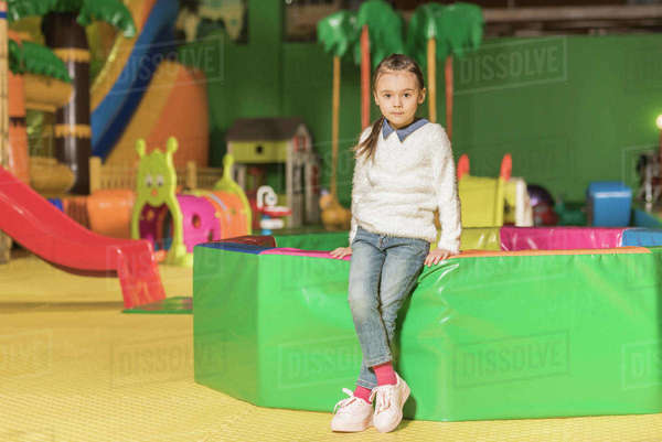 cute little child looking at camera while standing in entertainment ...