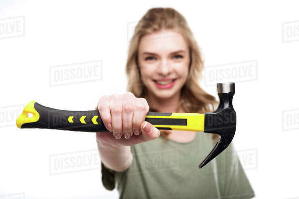Woman holding hammer and looking at camera isolated on white ...