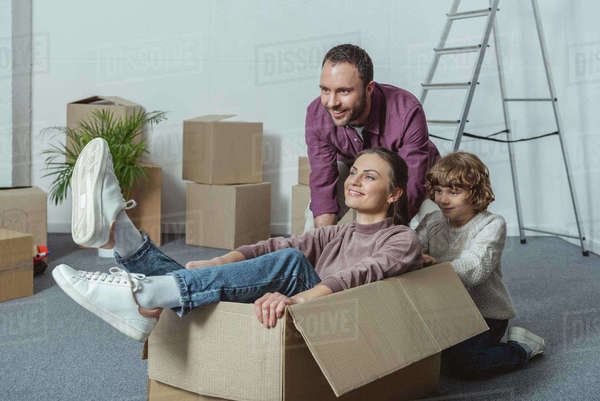 Happy family having fun while moving in new home - Stock Photo - Dissolve
