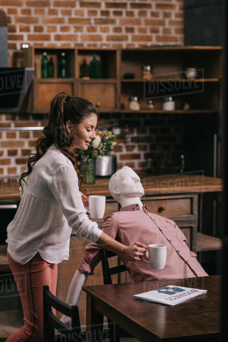 Woman serving coffee to manikin at home, perfect relationship dream ...
