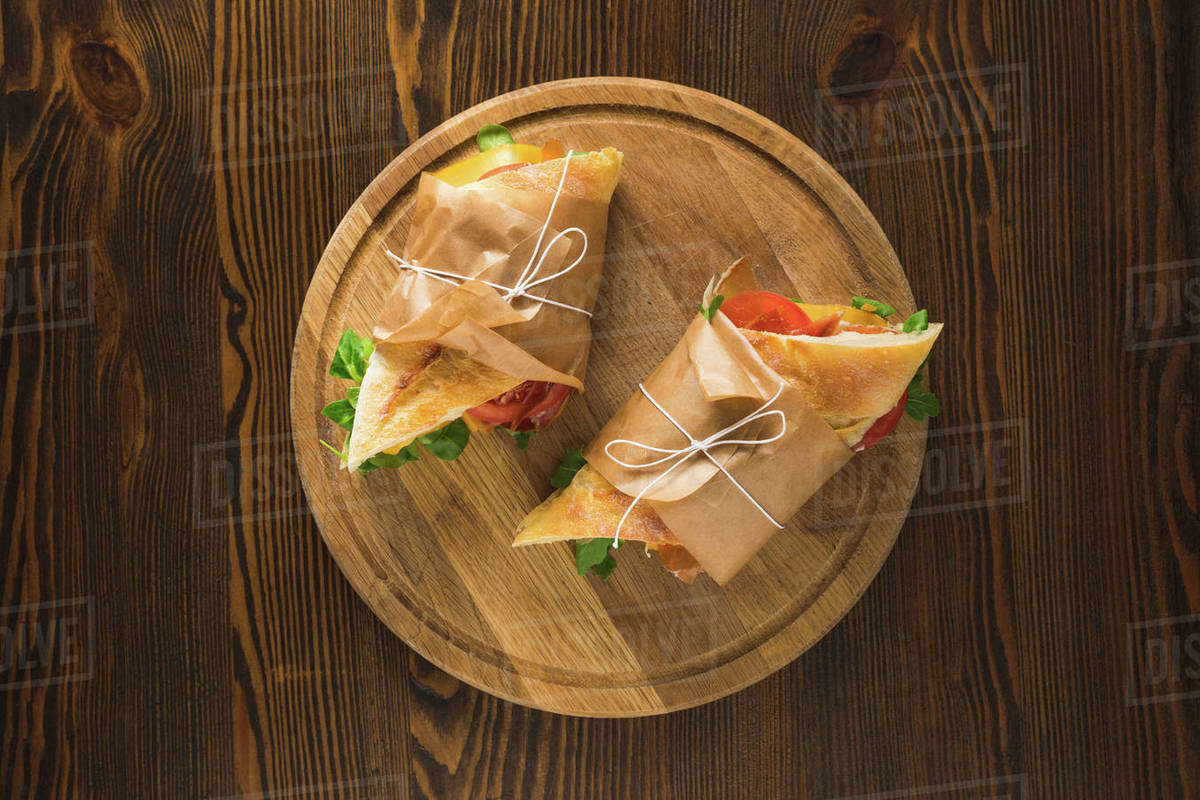Top view of two delicious panini on wooden round board - Stock Photo ...