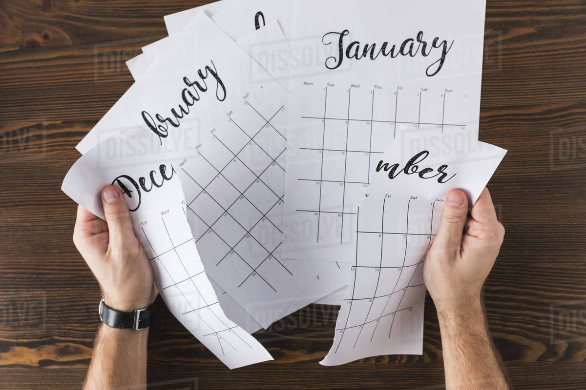 Cropped shot of man tearing calendar on wooden tabletop - Royalty-free ...