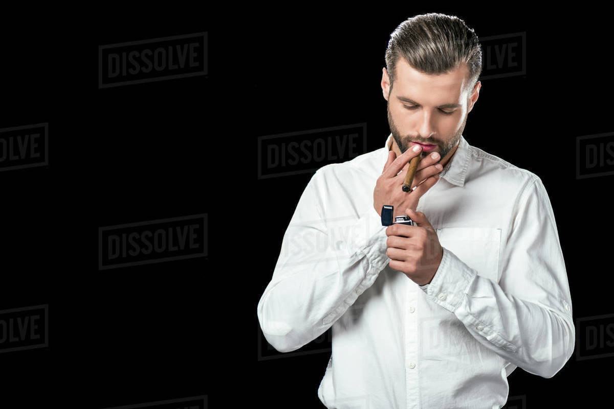 Handsome man lightning cigar with lighter, isolated on black - Royalty ...