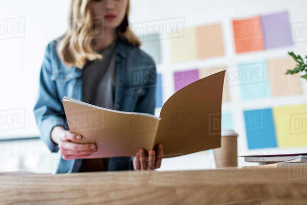 Cropped view of magazine editor working in modern office with color ...