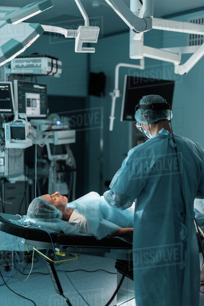 Surgeon operating patient in operating room - Stock Photo - Dissolve
