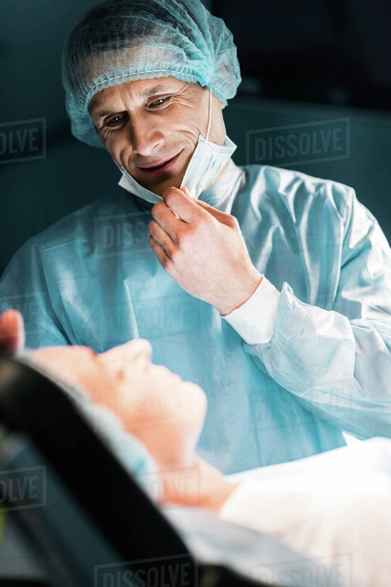 Smiling doctor looking at patient in surgery room - Royalty-free Stock ...