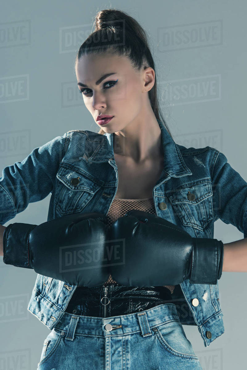 stylish model in denim clothes and boxing gloves, isolated on grey ...