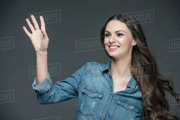 attractive cheerful girl waving isolated on grey - Royalty-free Stock ...