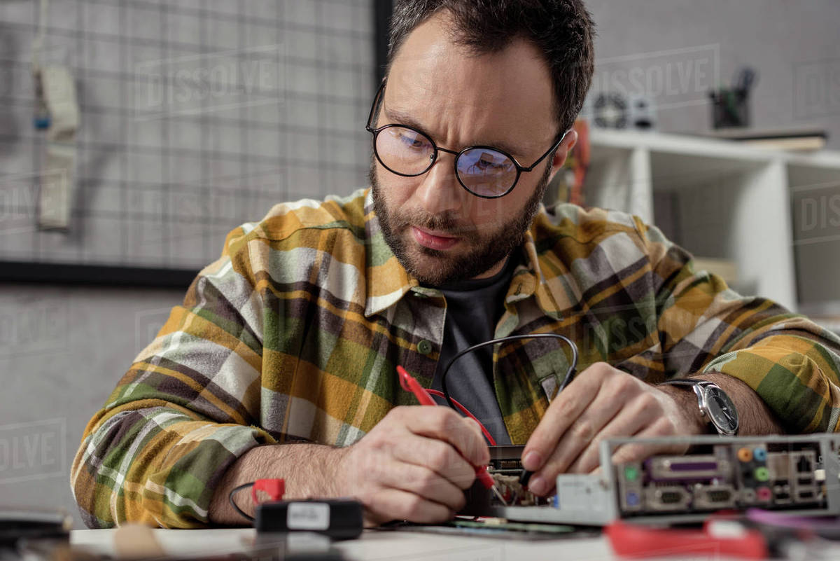 man using multimeter while fixing broken computer - Royalty-free Stock ...