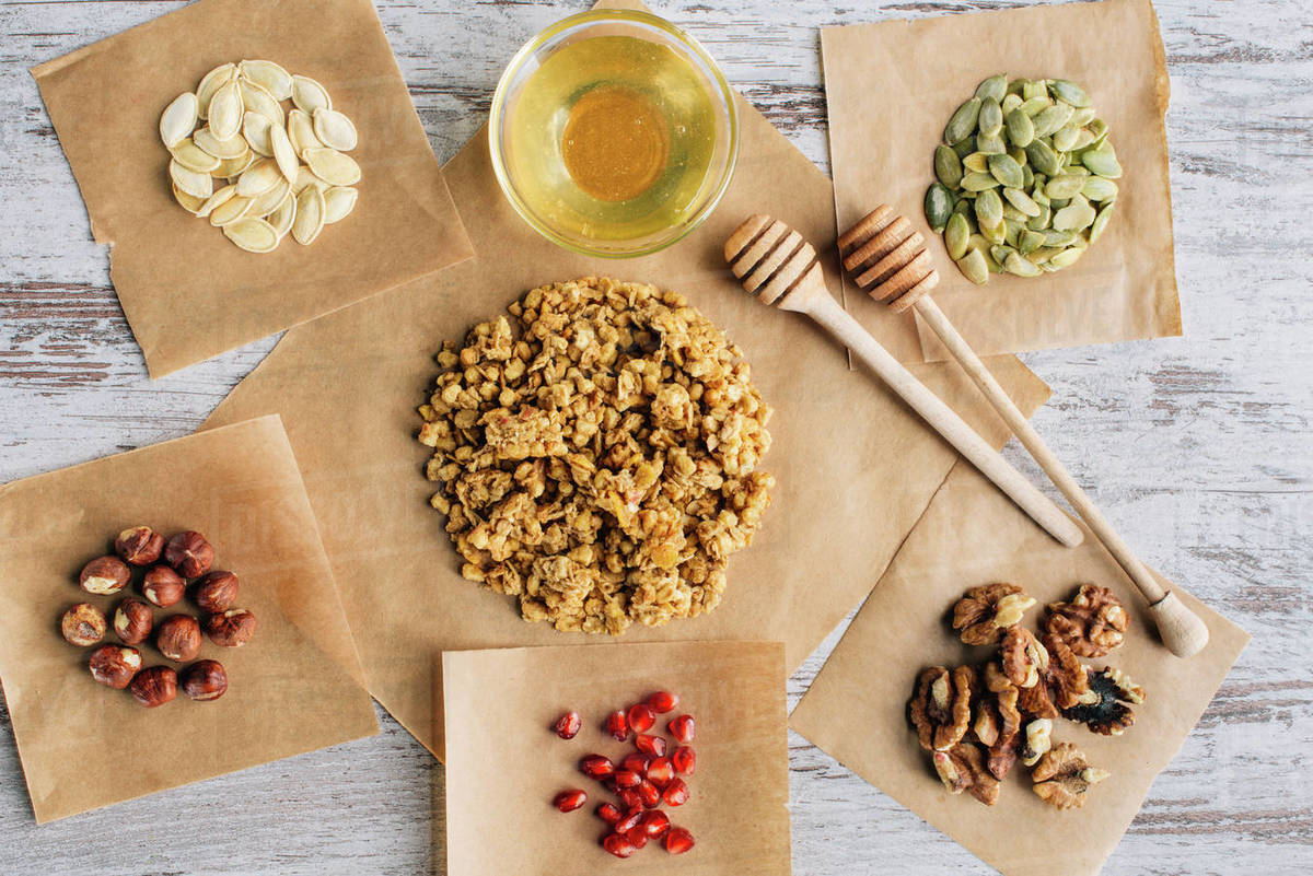 Top view of homemade granola ingredients on baking parchment pieces ...
