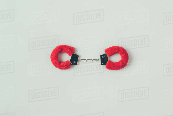 Top view of locked red fluffy handcuffs isolated on white - Royalty ...