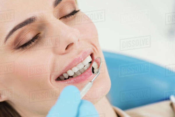 Doctor checking patient teeth with mirror in modern dental clinic ...
