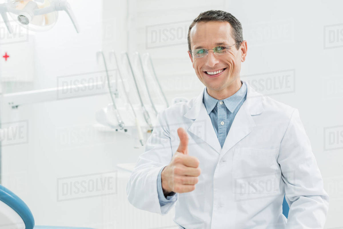 Dentist showing thumb up in modern dental clinic - Royalty-free Stock ...