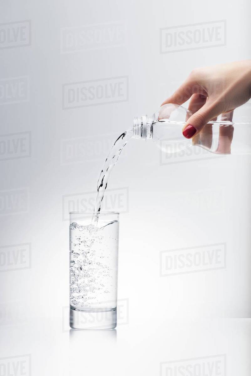 Cropped shot of woman pouring water into glass from plastic bottle - Royalty-free Stock Photo ...