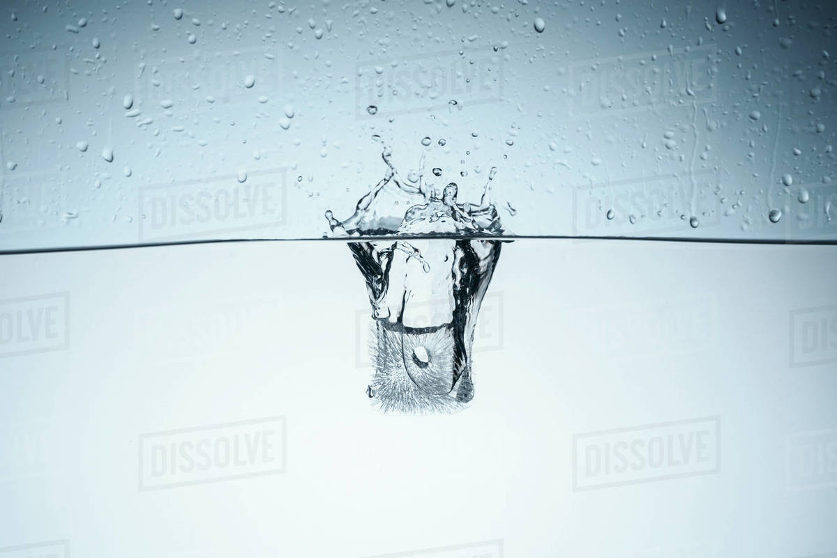 Ice cube splashing in water, isolated on white - Royalty-free Stock Photo | Dissolve