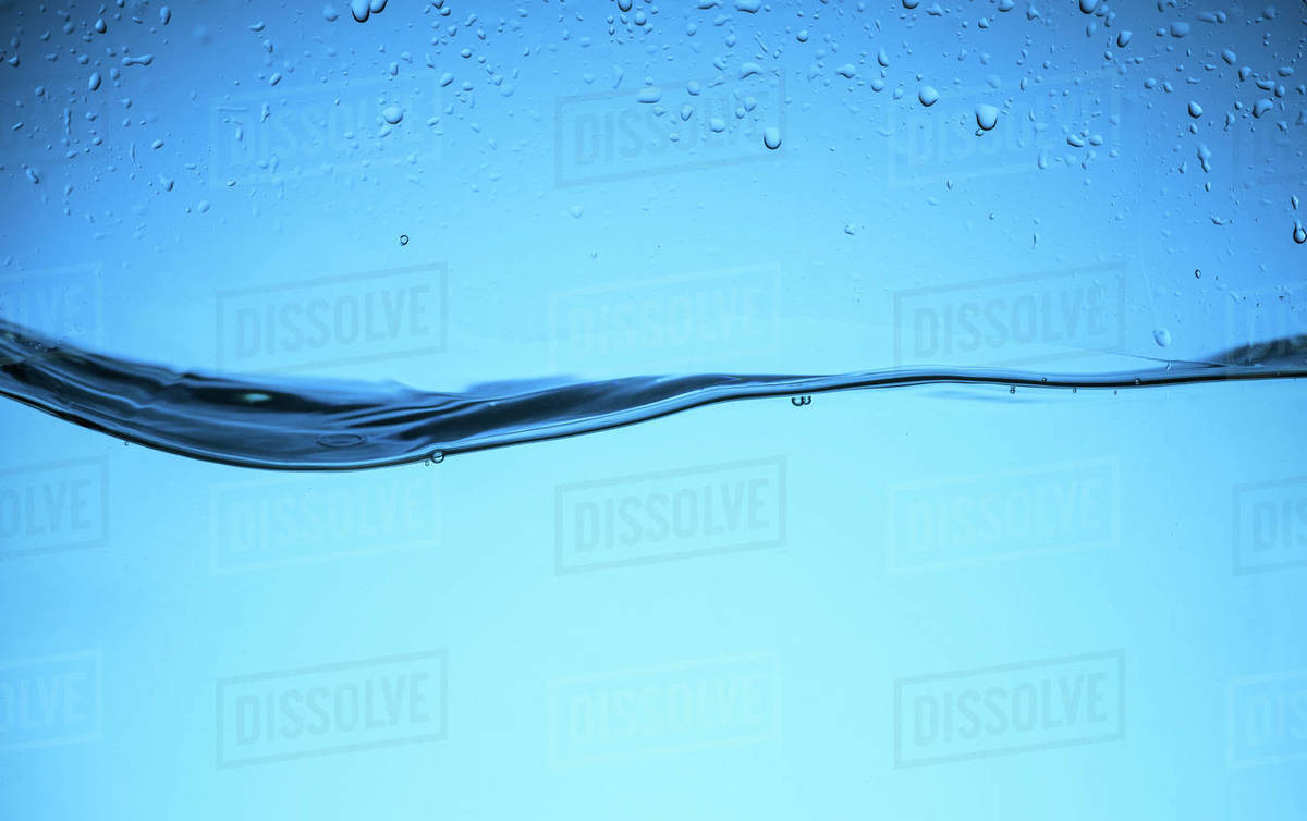 Flowing water texture with drops, isolated on blue - Stock Photo - Dissolve