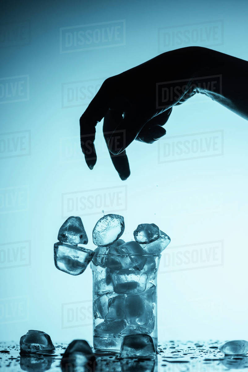 Cropped view of person throwing ice cubes into glass - Royalty-free ...
