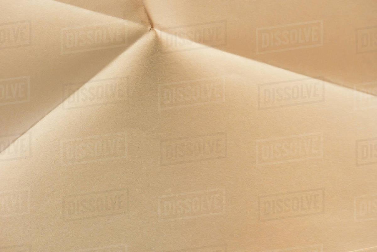 Close-up shot of folded beige color paper - Stock Photo - Dissolve