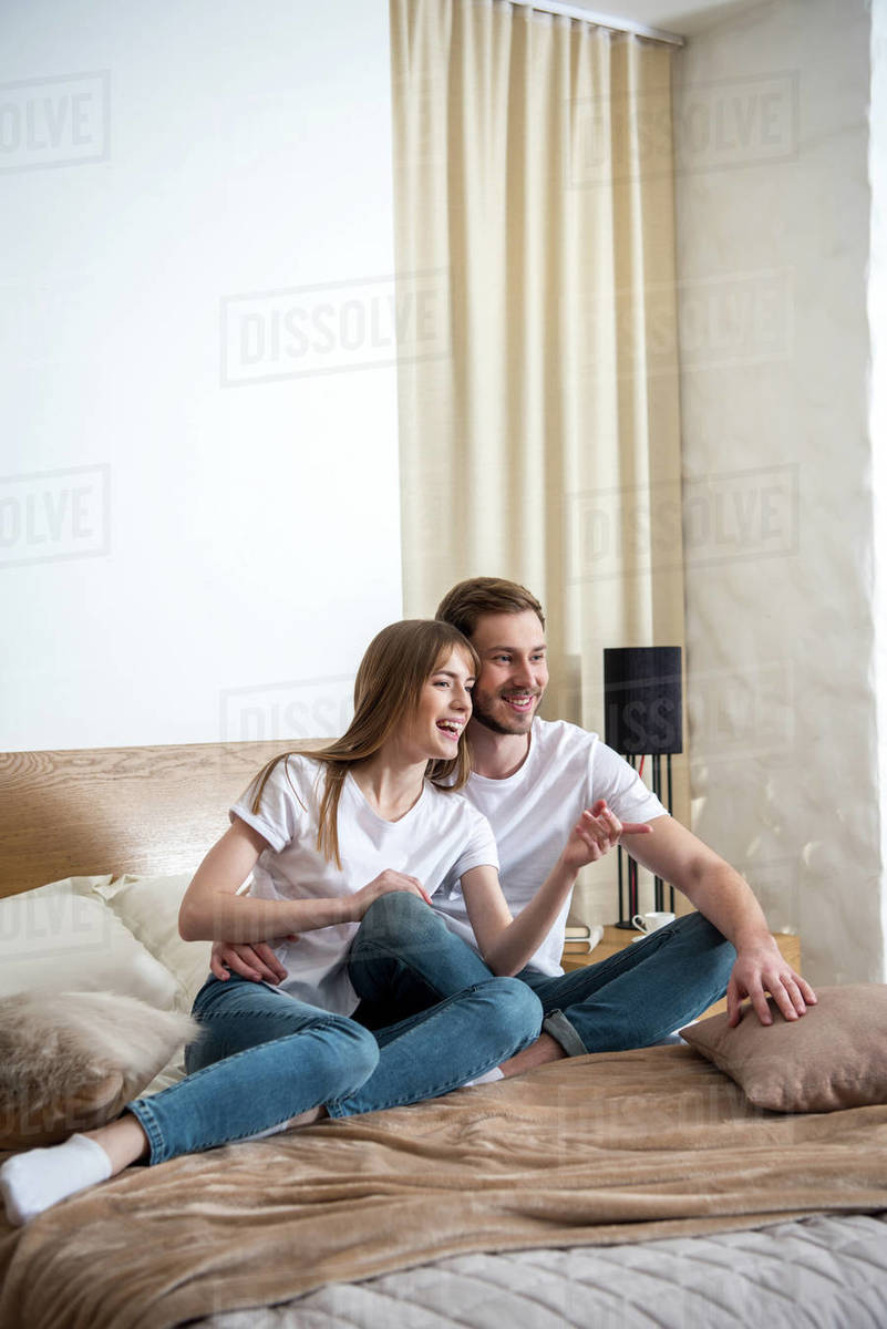 Young smiling woman with boyfriend in bedroom with modern design ...