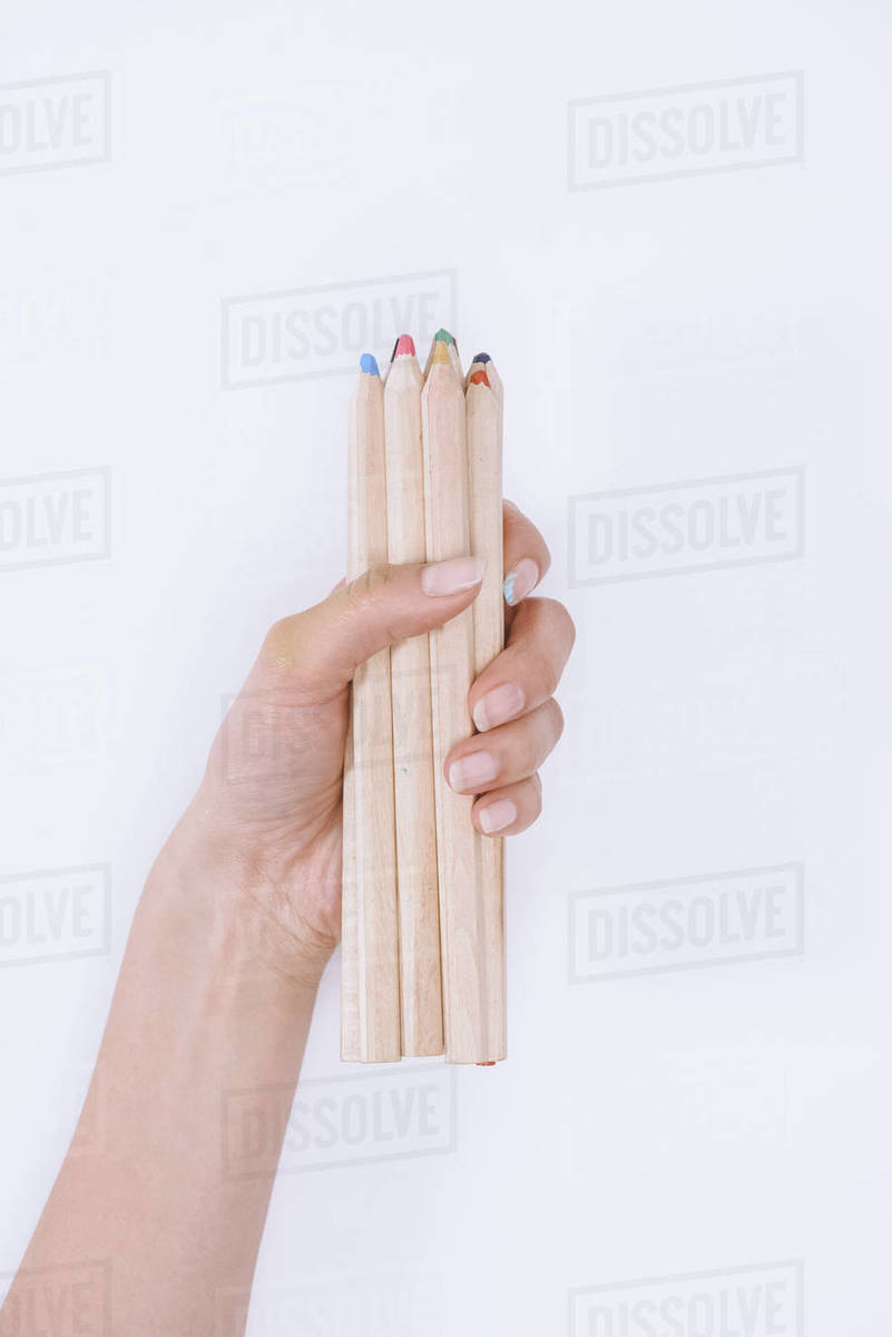 Close-up partial view of human hand holding crayons isolated on white ...