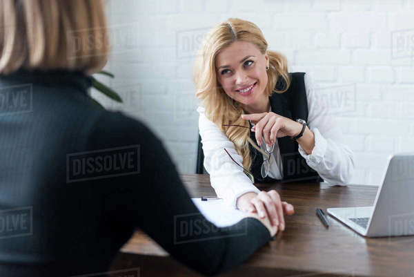 Smiling businesswoman palming coworker hand in office - Royalty-free ...