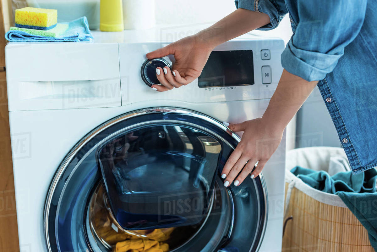 Cropped shot of woman using washing machine at home - Royalty-free ...