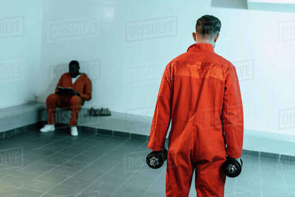 rear view of prisoner training with dumbbells in prison cell - Royalty ...