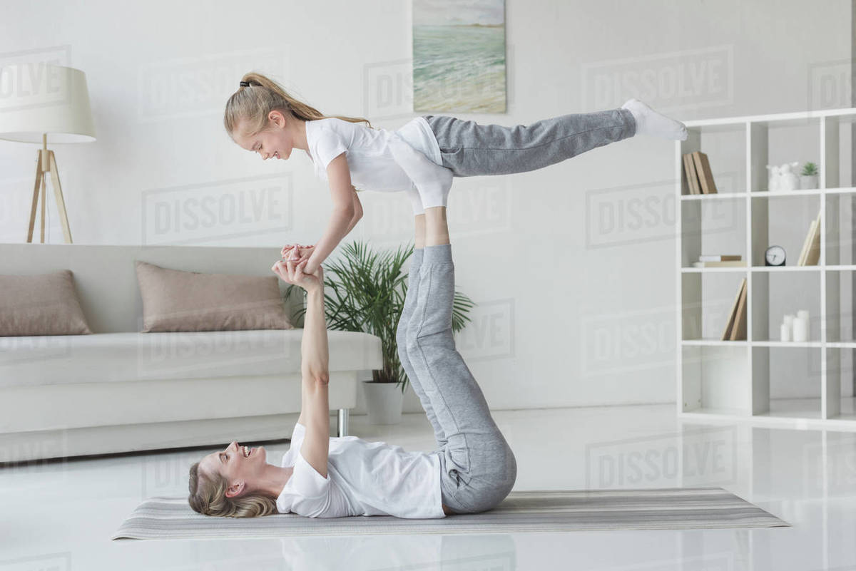 Mother and daughter practicing acro yoga at home - Royalty-free Stock ...