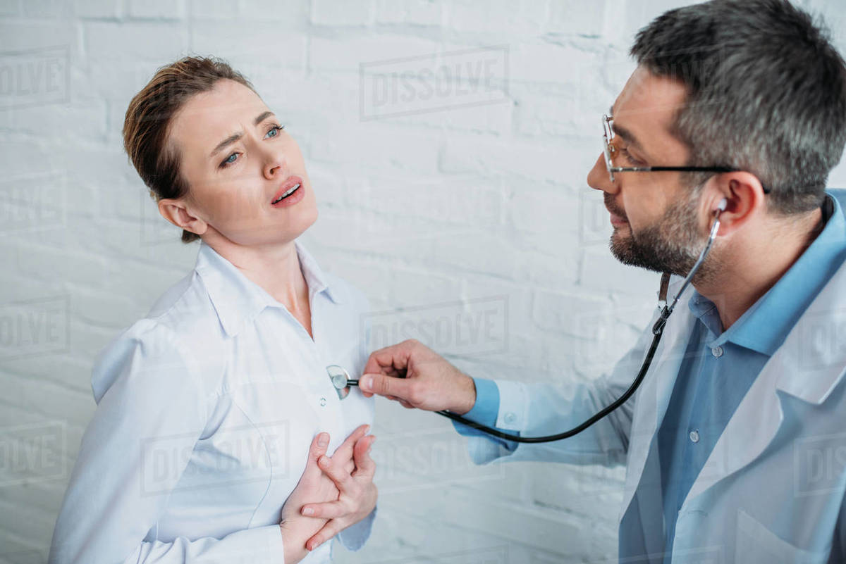 Doctor listening to heartbeat of patent with stethoscope - Stock Photo ...