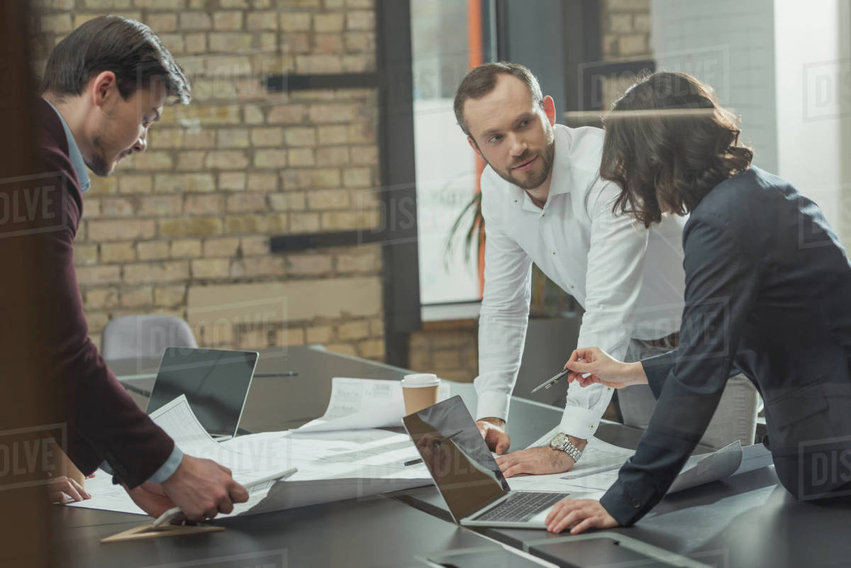 Team of young architects brainstorming on building plans - Royalty-free ...